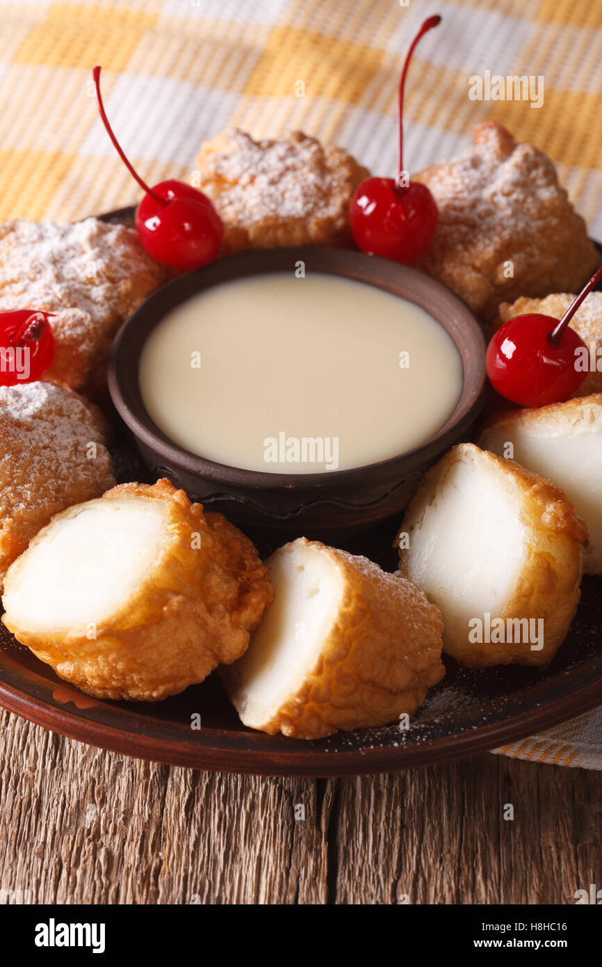 Fried milk dessert with condensed milk close-up on a plate. Vertical ...