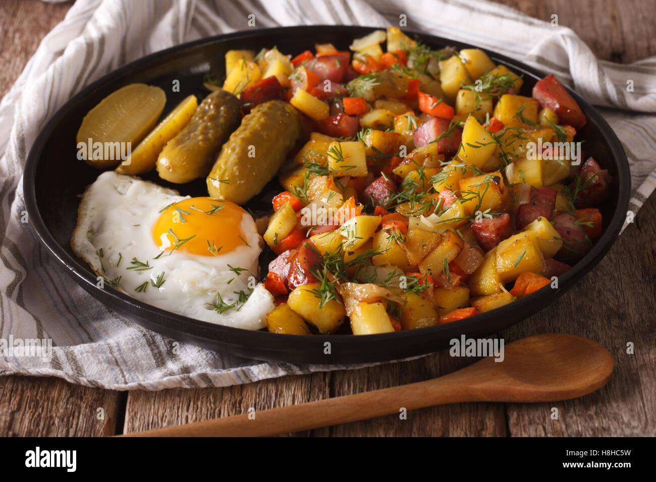 Finnish food pyttipannu: fried potatoes with sausages, eggs and pickled ...