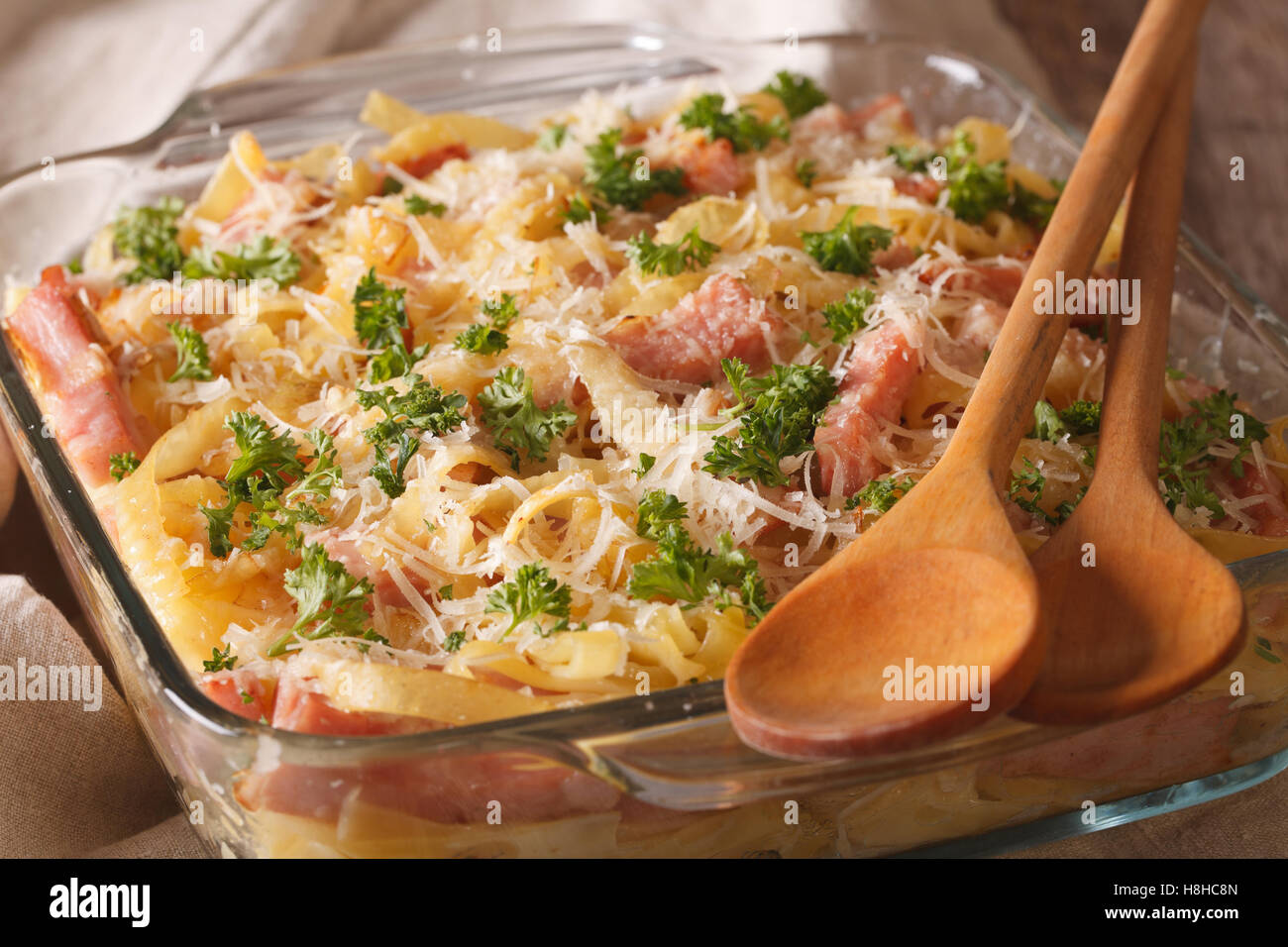 Austrian noodles baked with ham and parmesan close-up in a glass baking ...