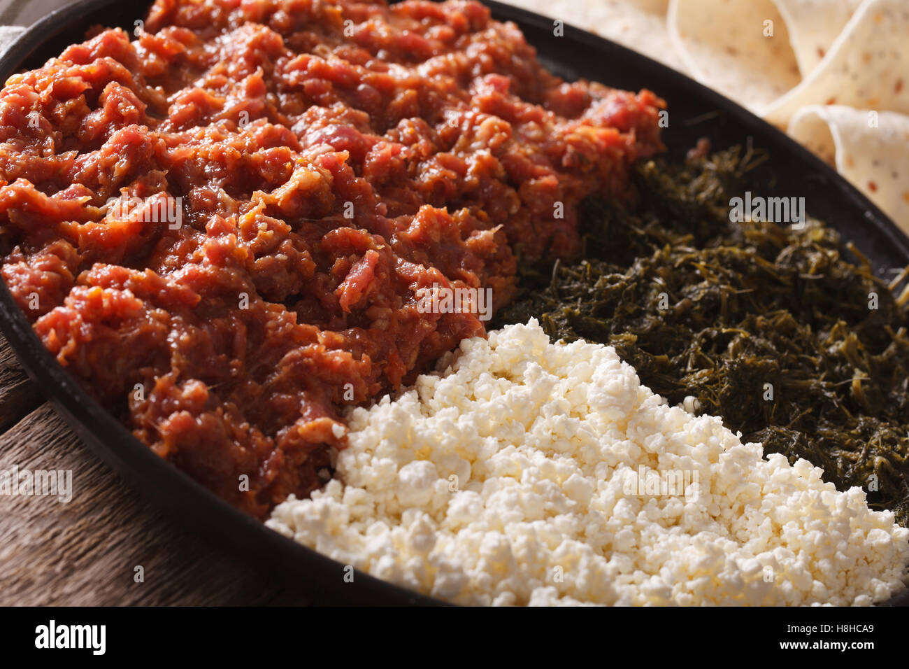 Ethiopian kitfo with herbs and cheese ayibe on a plate close-up ...