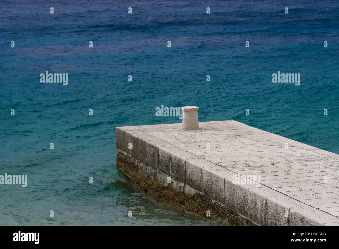 Traditional stone pier and blue sea in backgound Stock Photo - Alamy