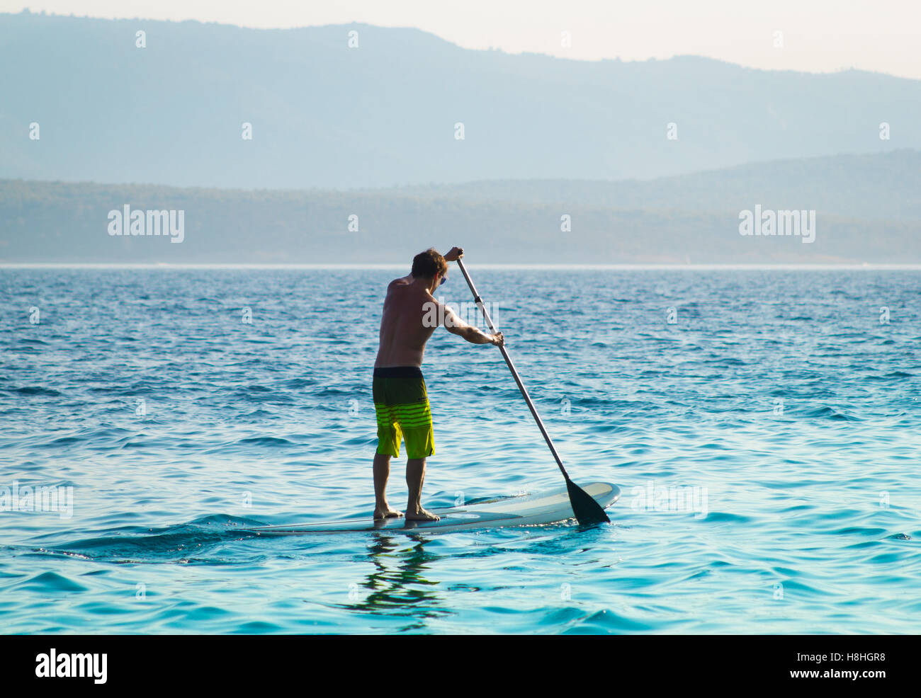 Man paddleboarding sufring on sea Stock Photo - Alamy