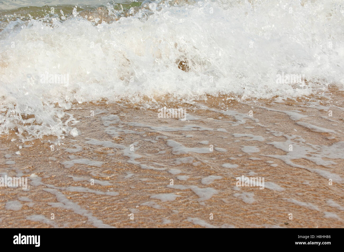 Wave splashing on a beach Stock Photo - Alamy
