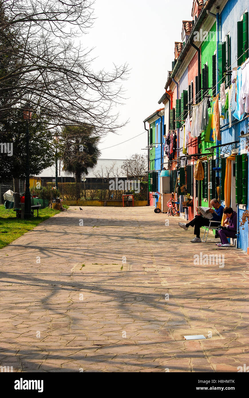 Two persons enjoy the sun outside their house Stock Photo - Alamy