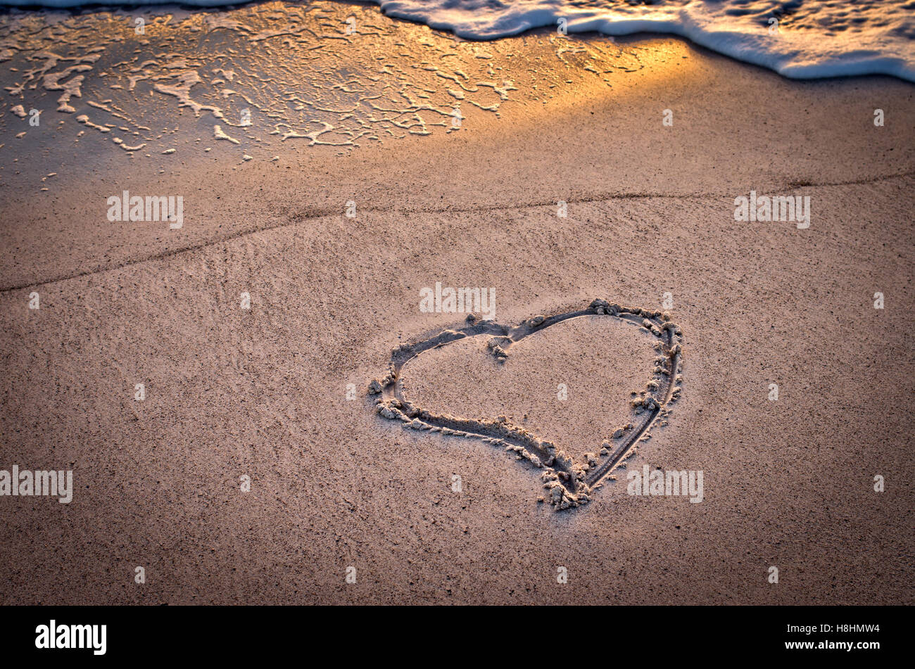 a heart waiting for you on the beach by the sea lit by the sunset Stock ...