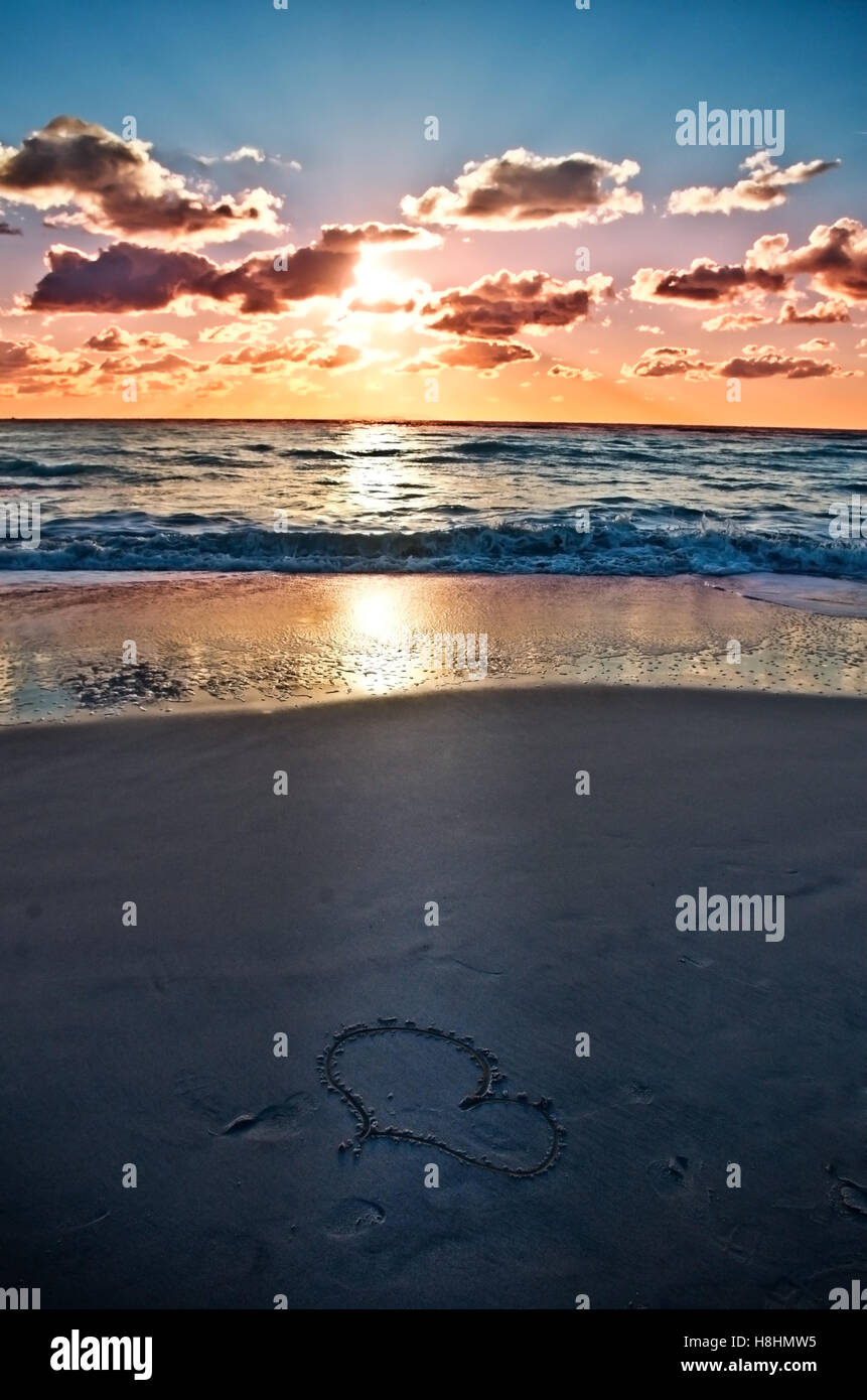 a heart waiting for you on the beach by the sea lit by the sunset Stock ...