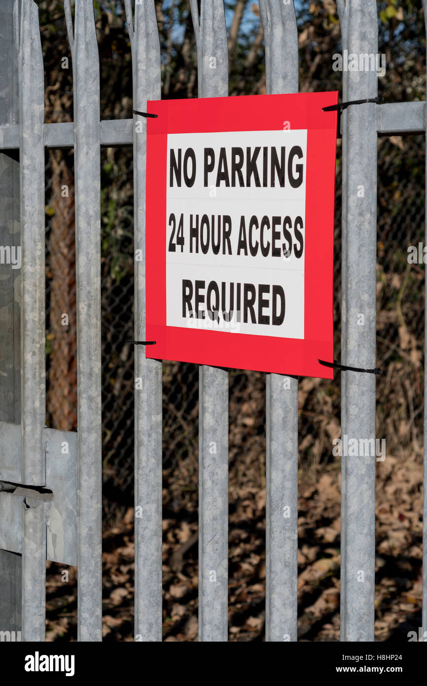 No Parking sign fixed to industrial metal fencing. No or limited access ...