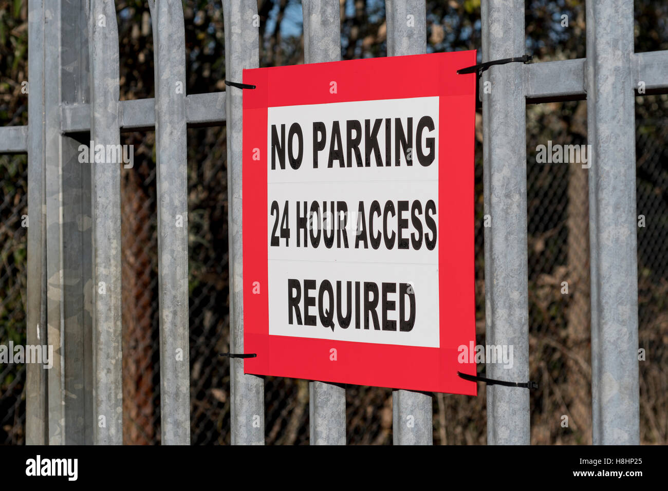 No Parking sign fixed to industrial metal fencing. No or limited access ...