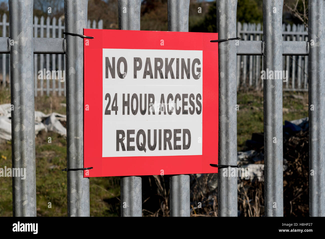 No Parking sign fixed to industrial metal fencing. No or limited access ...