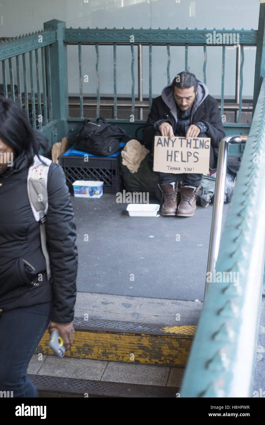 Homeless man reaches out for help at a subway station entrance on ...