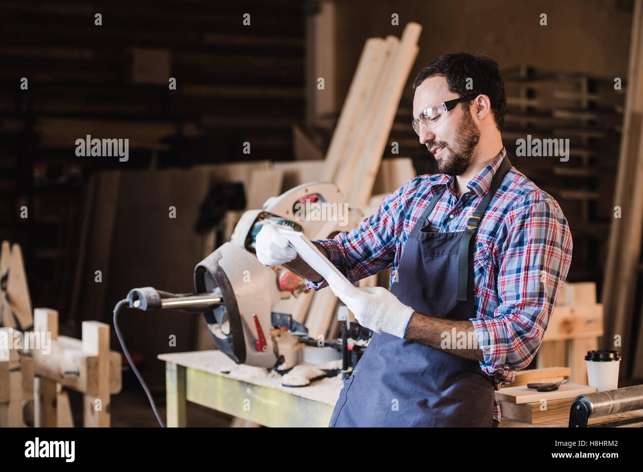 profession, carpentry, woodwork people concept - carpenter with wood ...