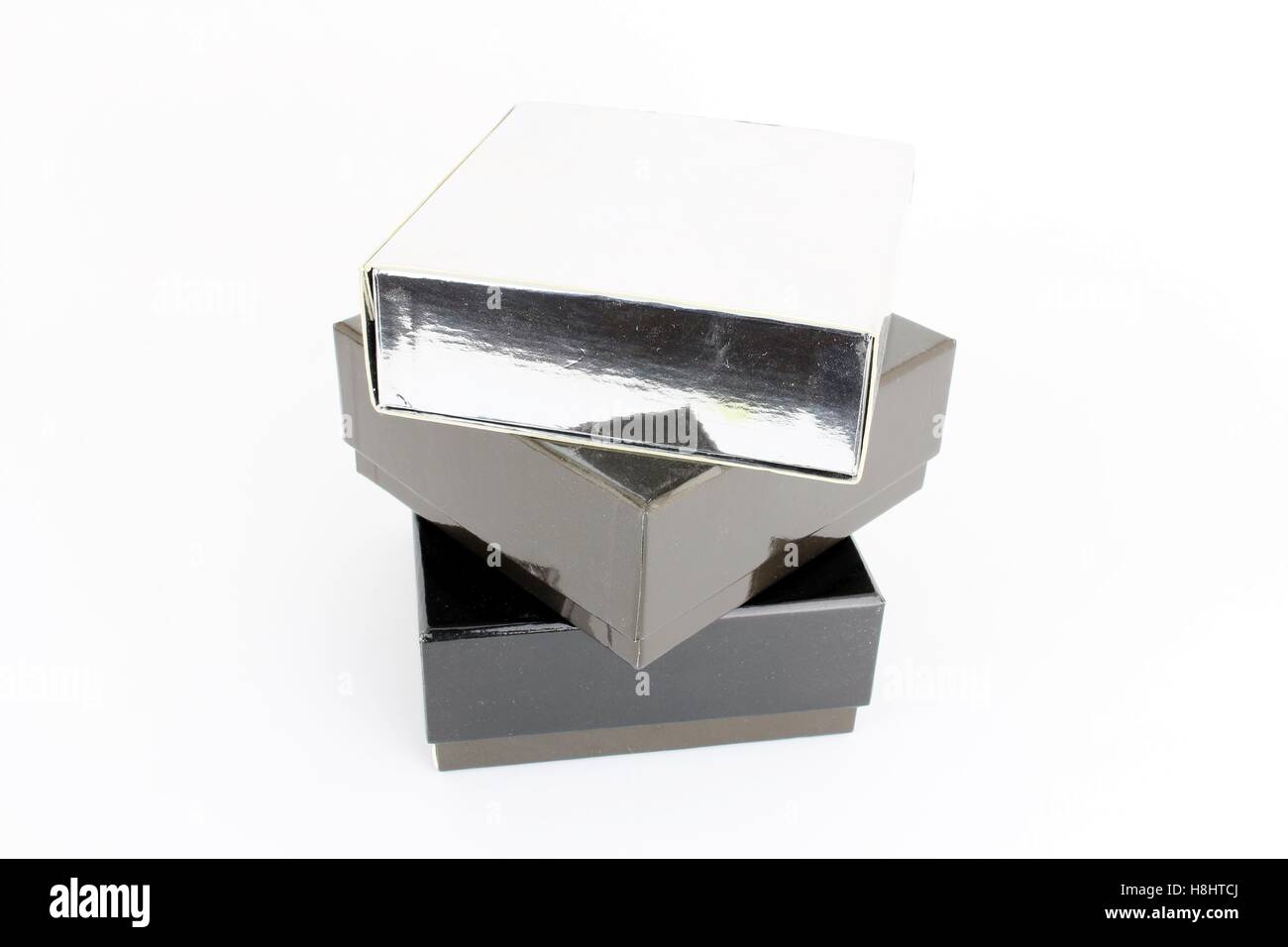 Stack of three books, vertically. silver, gray and black with white ...