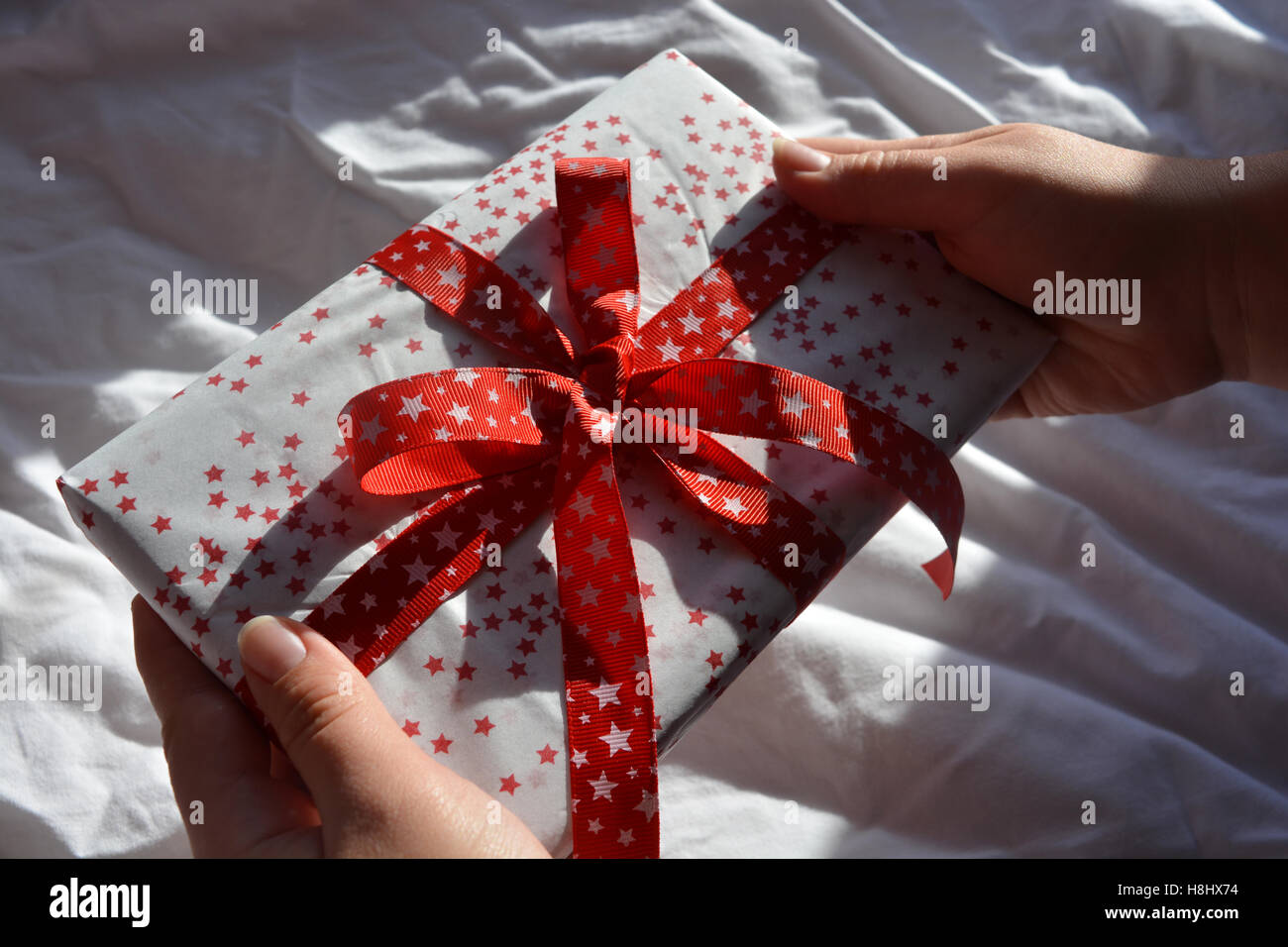 Hands holding a Christmas present, beautifully wrapped and decorated ...