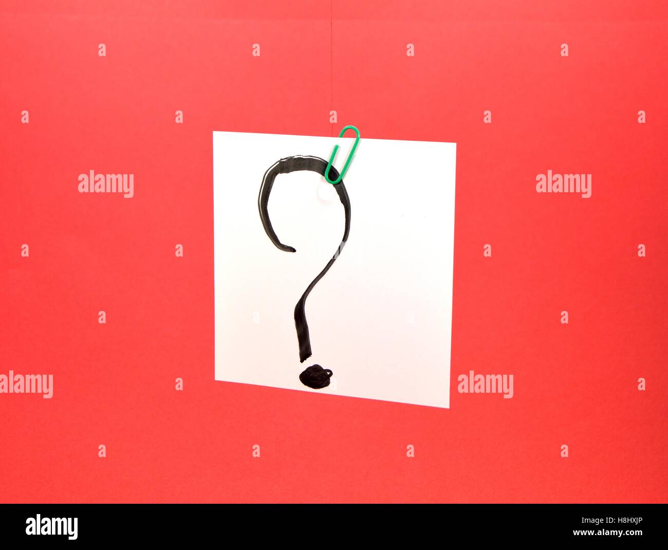 Question mark drawn on a post it in front of a red background Stock ...