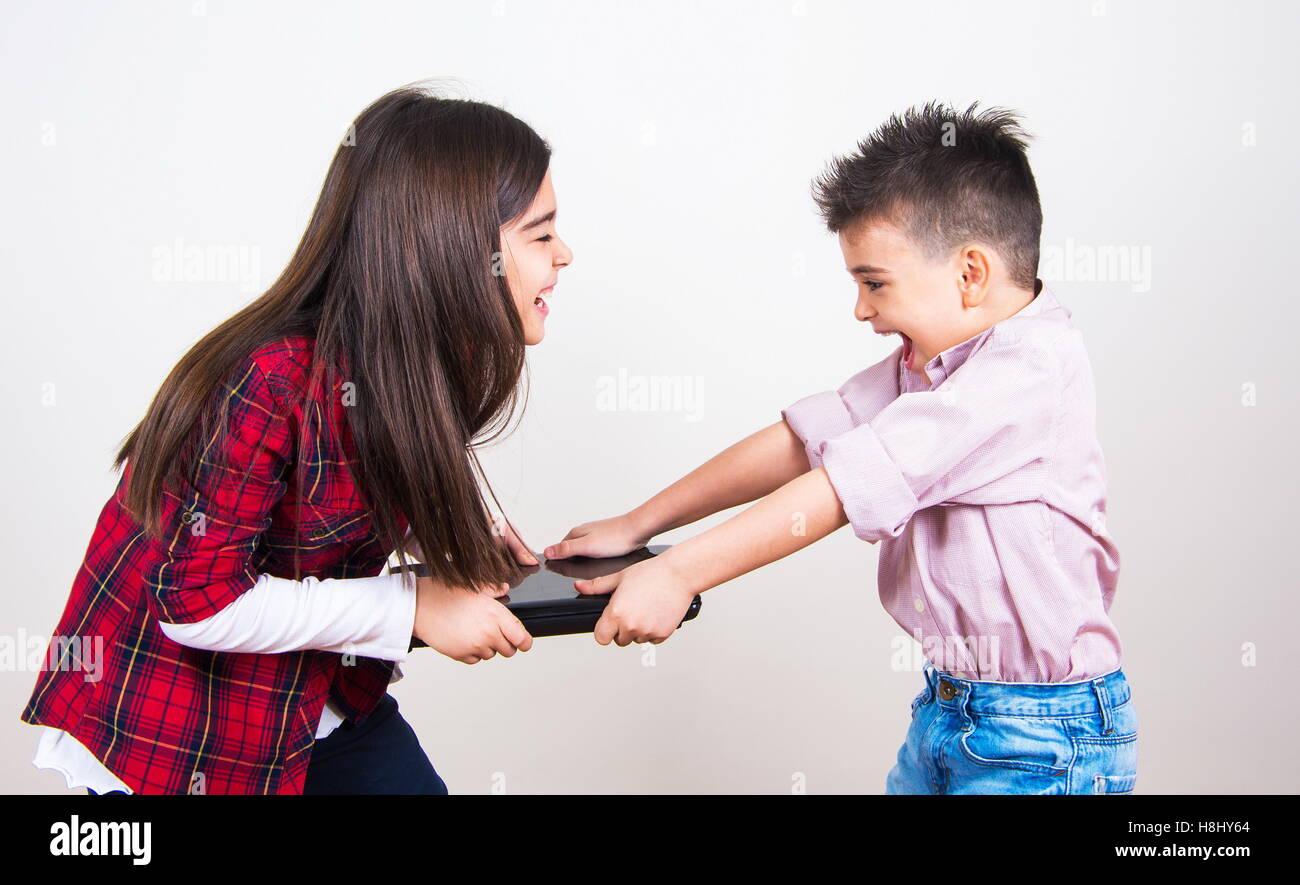 brother and sister fighting for the laptop Stock Photo - Alamy
