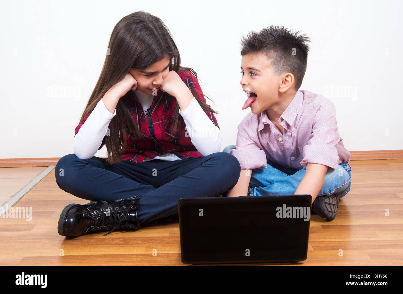 happy brother and sister using the laptop Stock Photo - Alamy