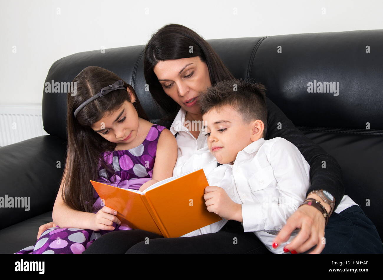 mother with children reading together Stock Photo - Alamy