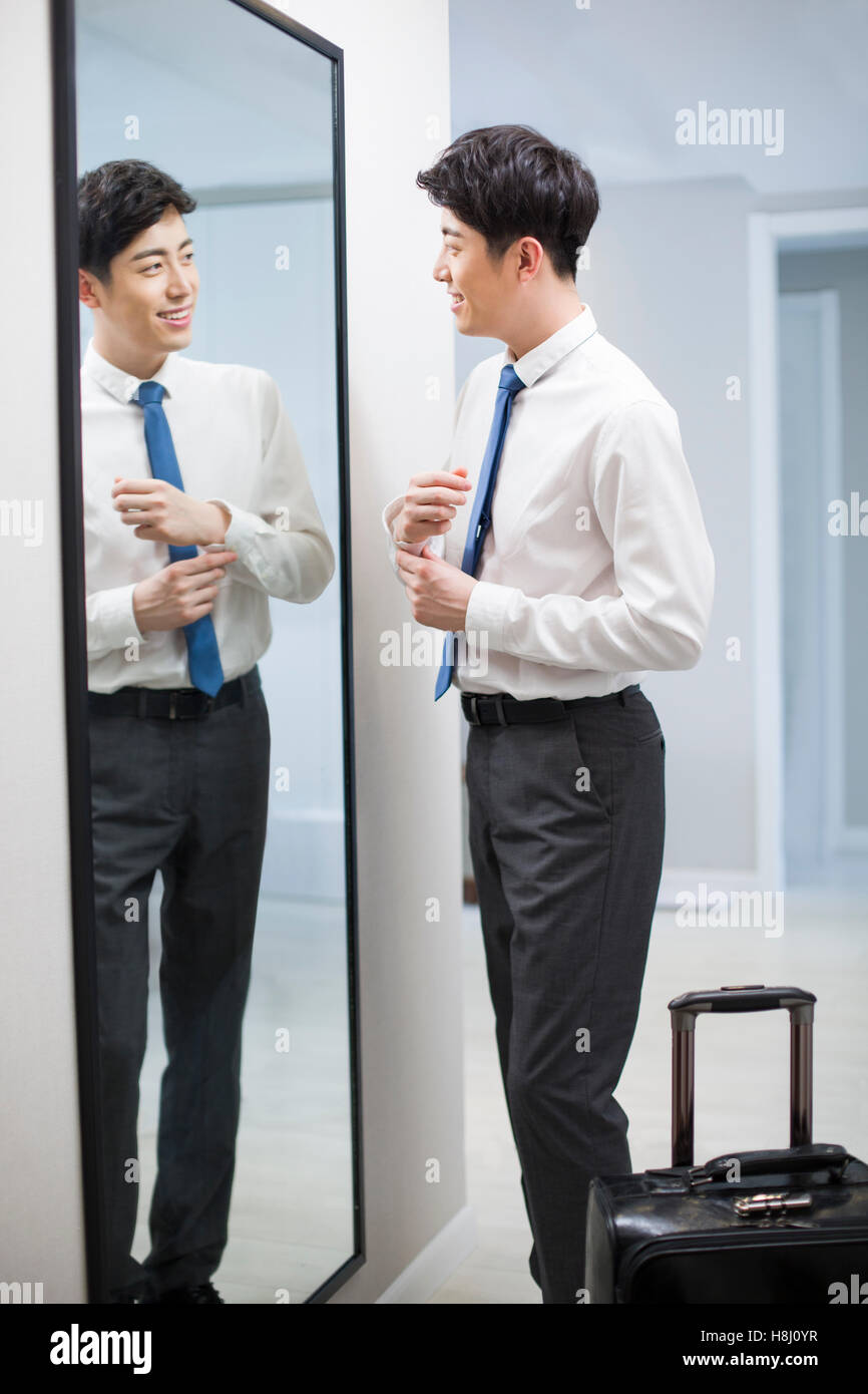Young Chinese man examining himself in front of mirror Stock Photo - Alamy