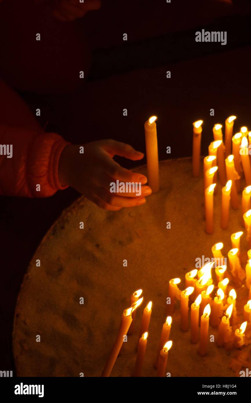 Woman hand lighting candles in a church Stock Photo - Alamy