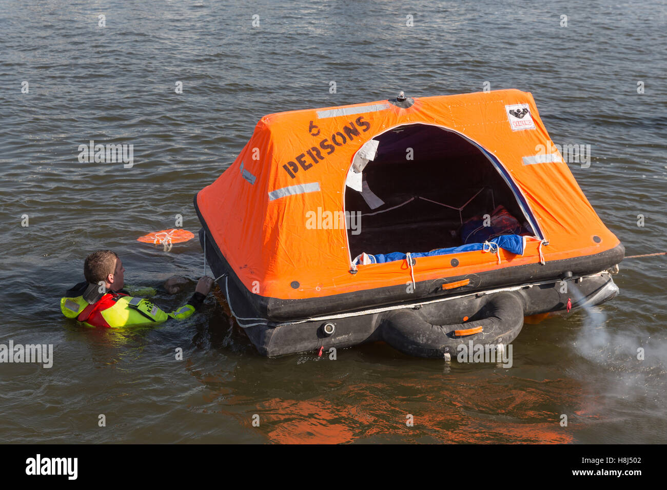 Rescue worker showing how to use a life raft in the harbor of Urk, the ...