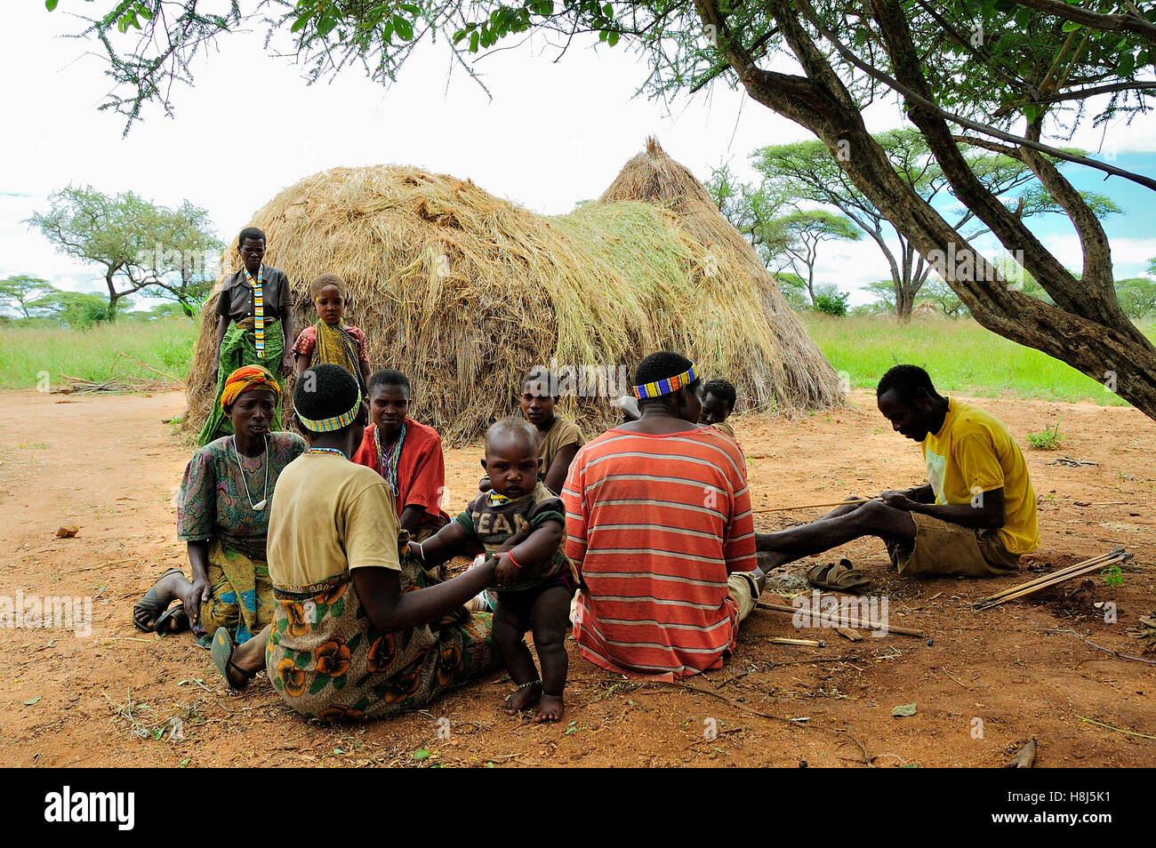 Hadzabe people in front of their thatch made hut Stock Photo - Alamy