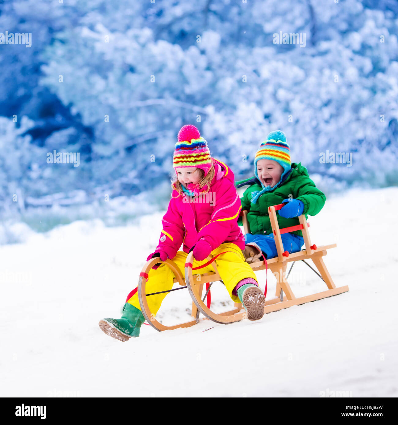 Little girl and boy enjoying sleigh ride. Child sledding. Toddler kid ...