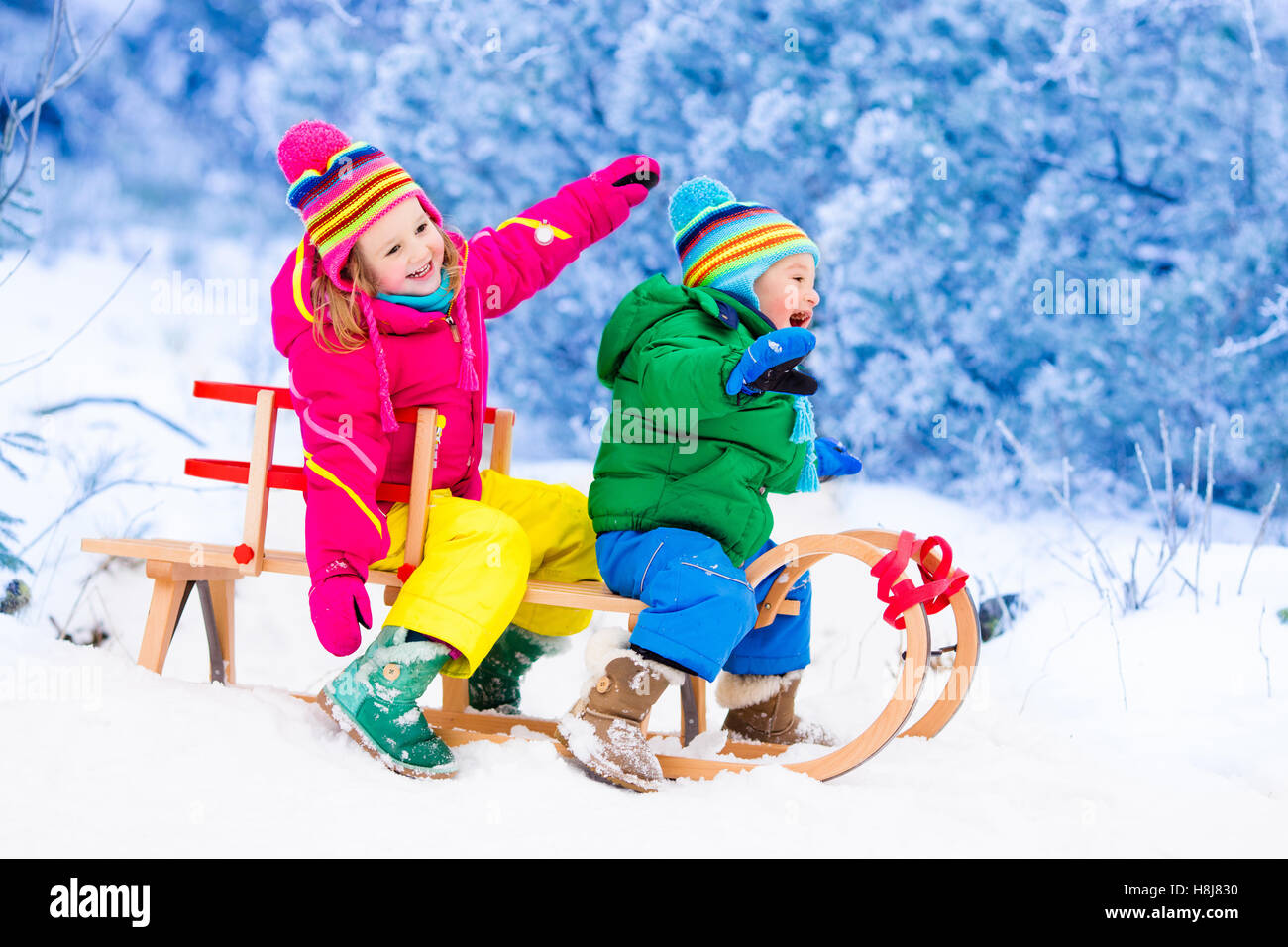 Little girl and boy enjoying sleigh ride. Child sledding. Toddler kid ...