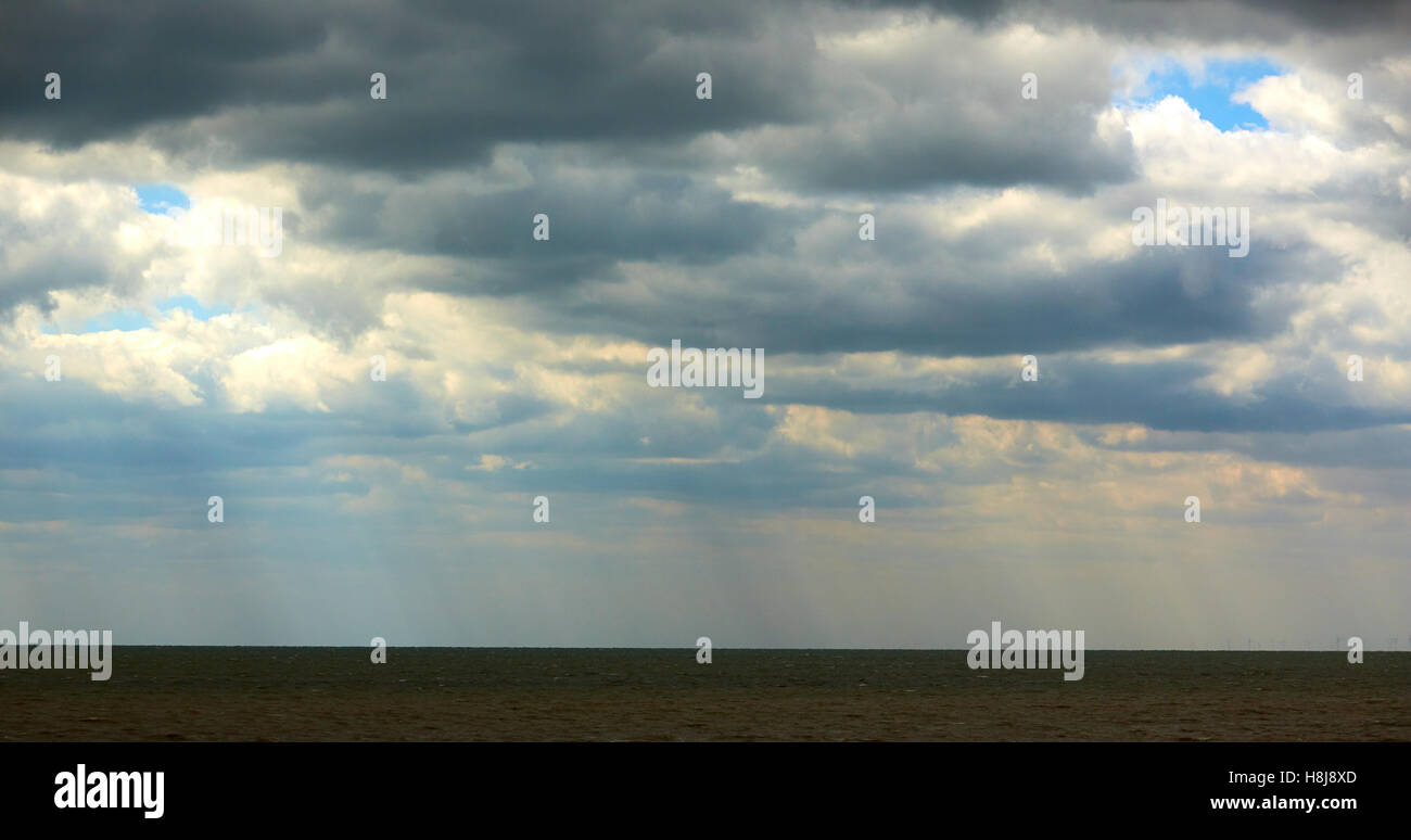 Sun beam through heavy sky over calm sea Stock Photo - Alamy