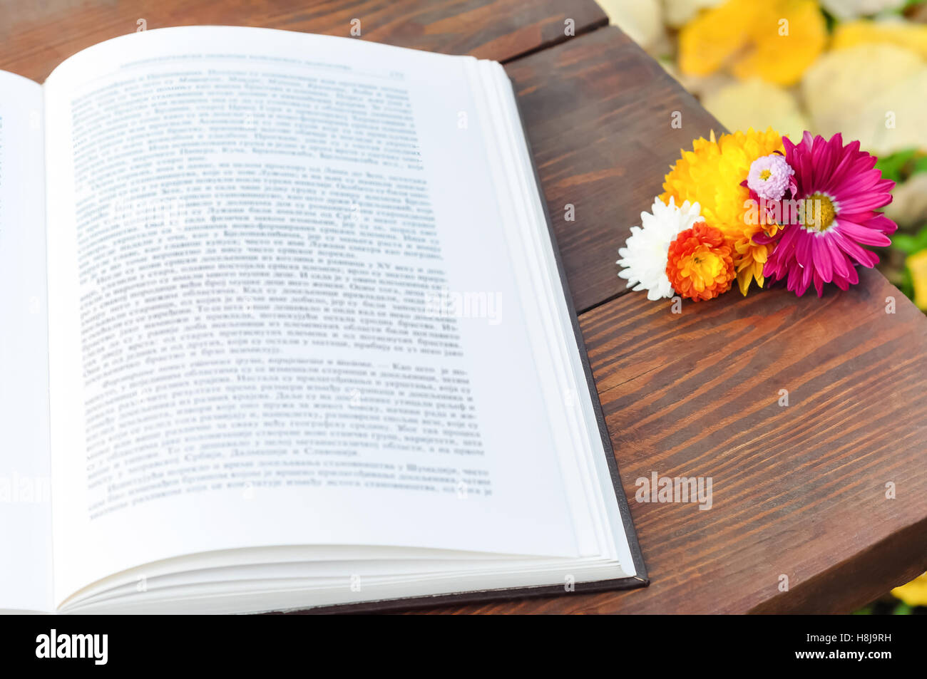 Open book on wooden table with flowers Stock Photo - Alamy