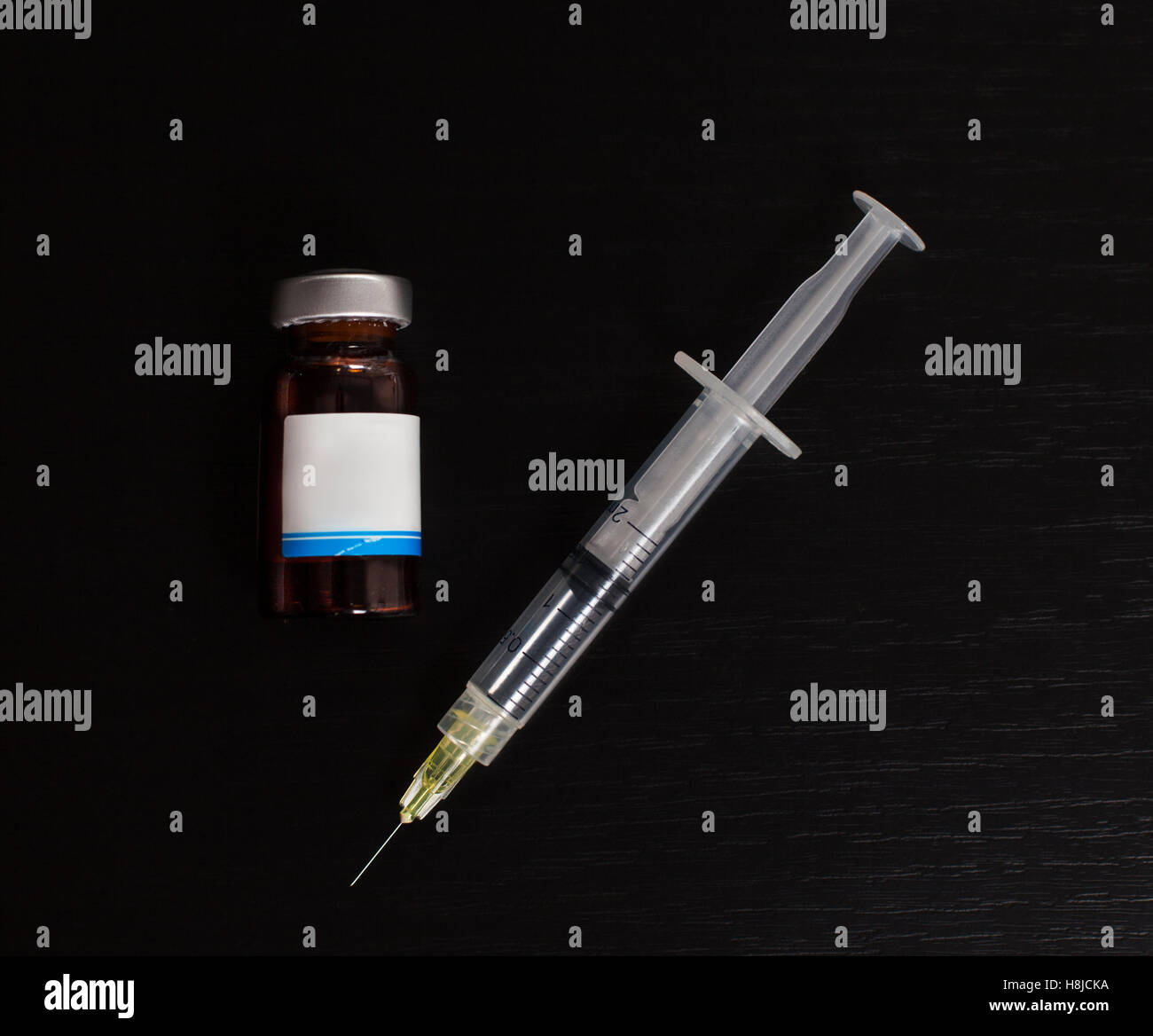 Syringe and bottle isolated on black background Stock Photo - Alamy