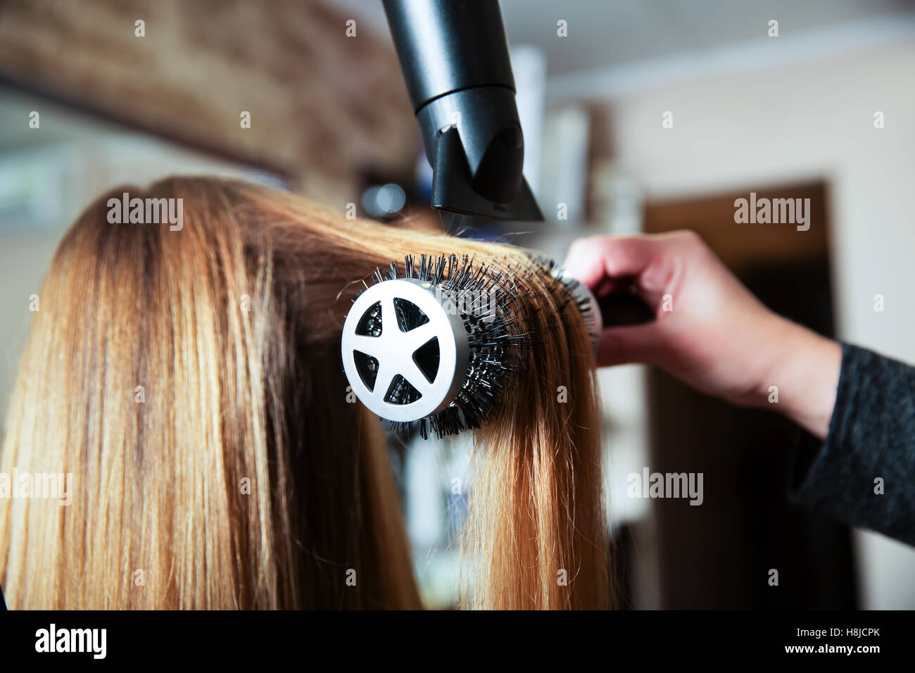 Making hairstyle using hair dryer Stock Photo - Alamy