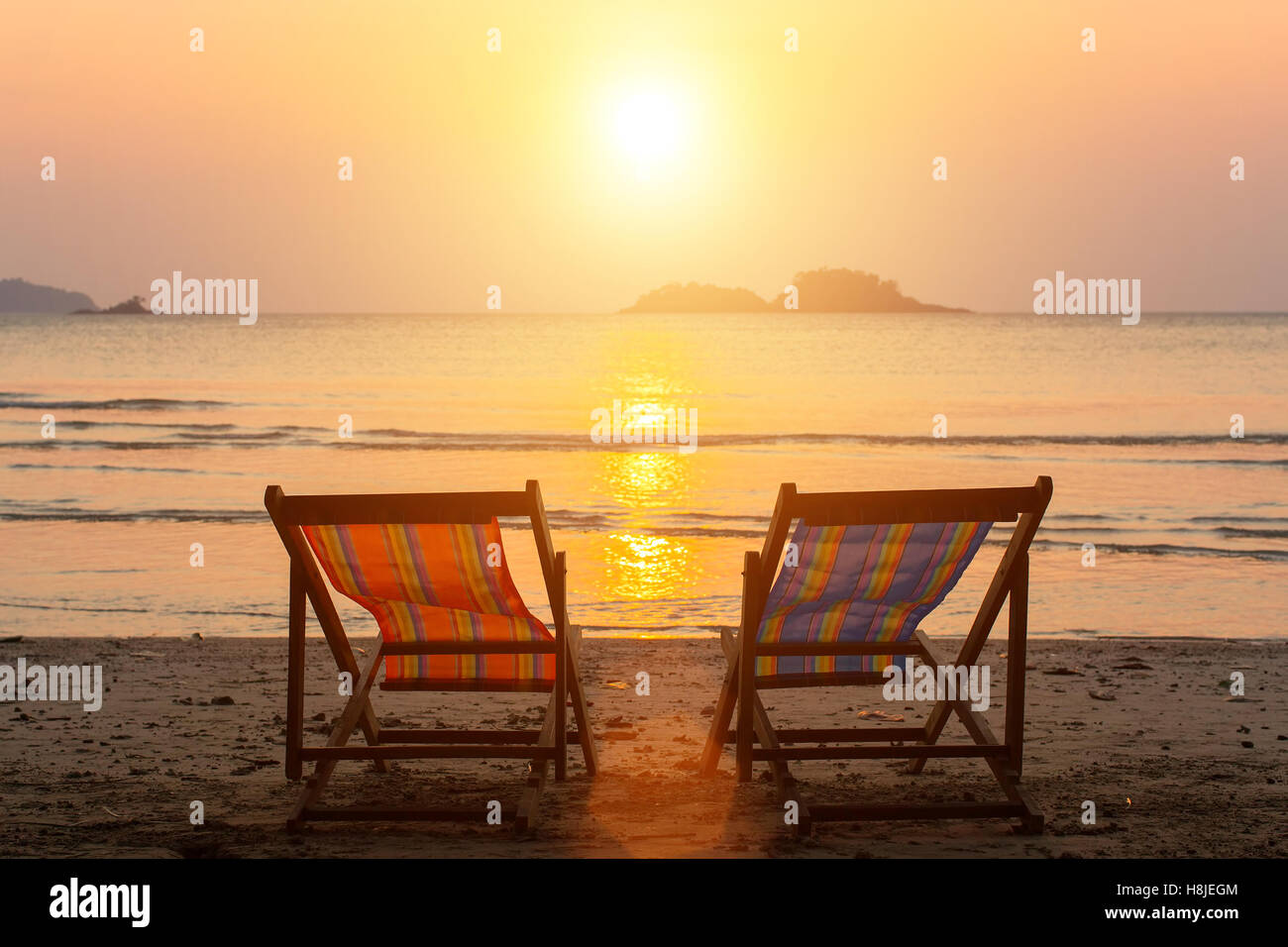 A couple of chairs on sunset beach Stock Photo - Alamy