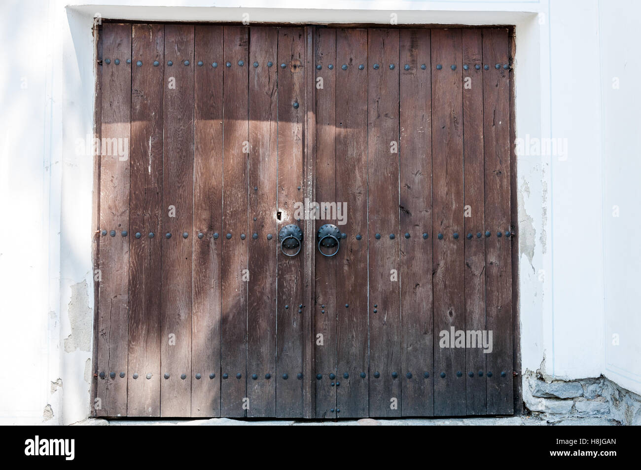 Brown wooden front door with random shadow casts and metallic handles ...