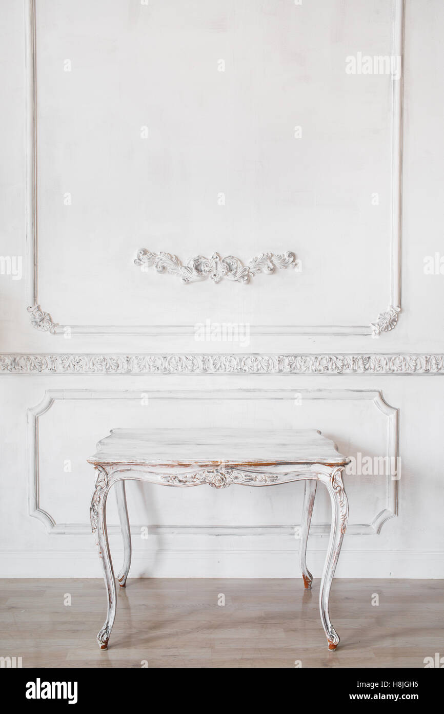 Living room with antique stylish light Coloured table on luxury white ...