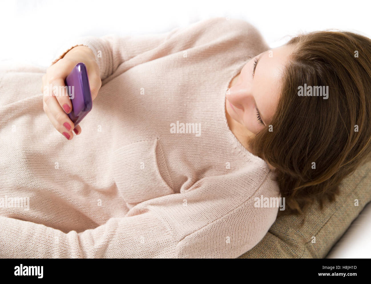 Young female using mobile relaxing in sofa Stock Photo - Alamy