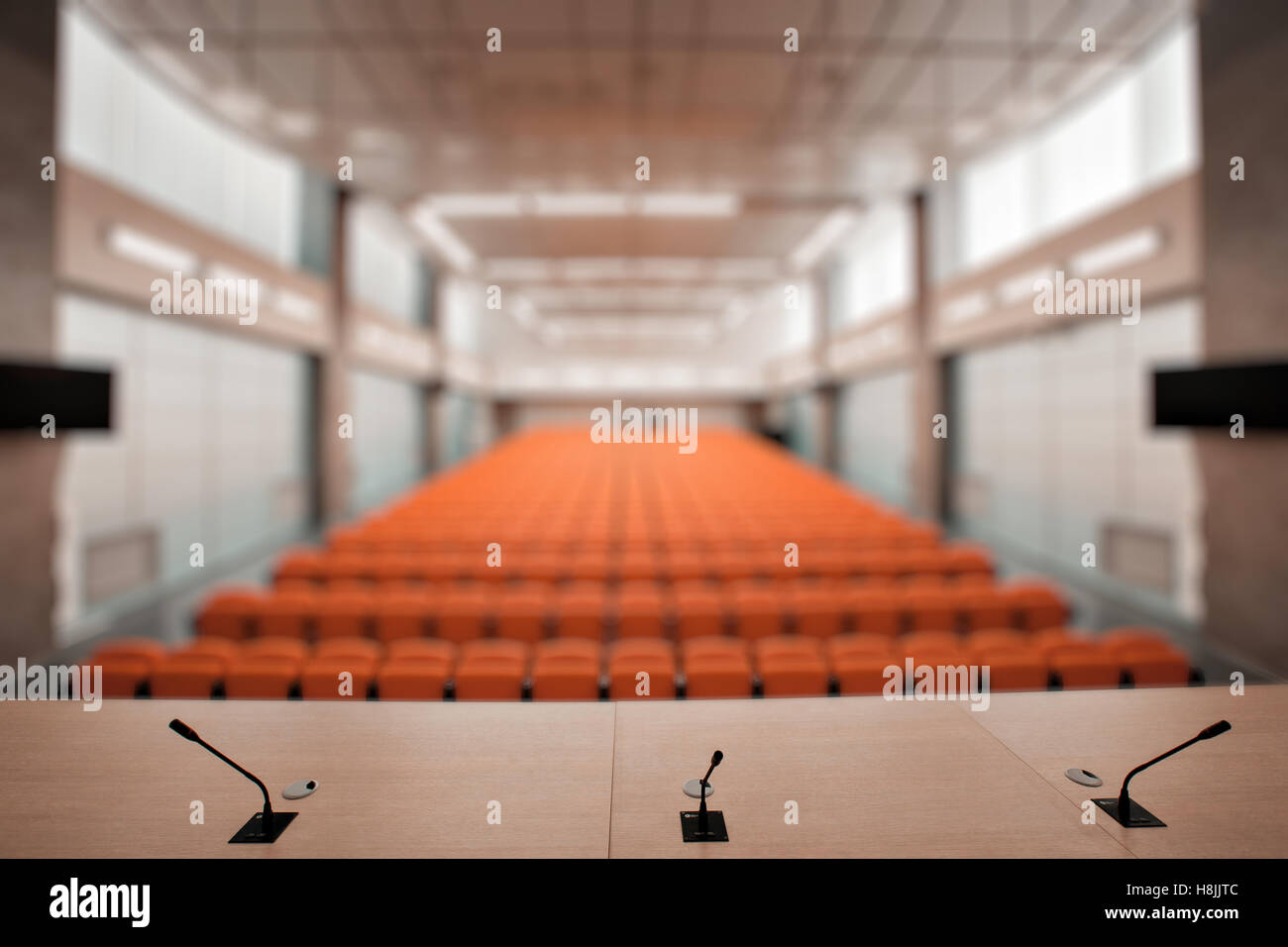 Abstract blur Rostrum with microphone and computer in conference hall ...