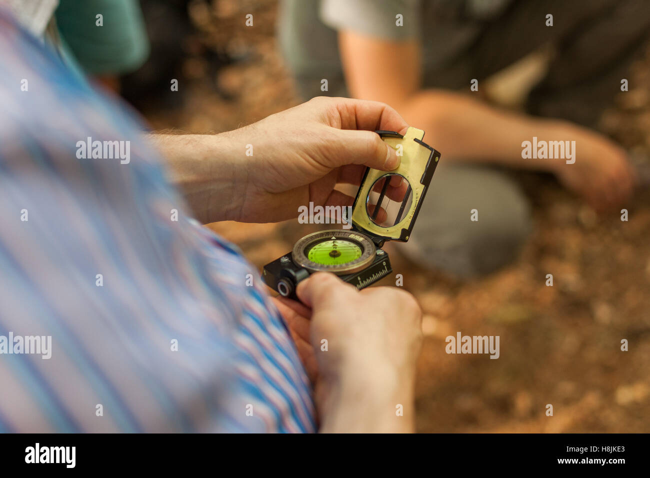 A man uses a compass to navigate through the forest Stock Photo - Alamy