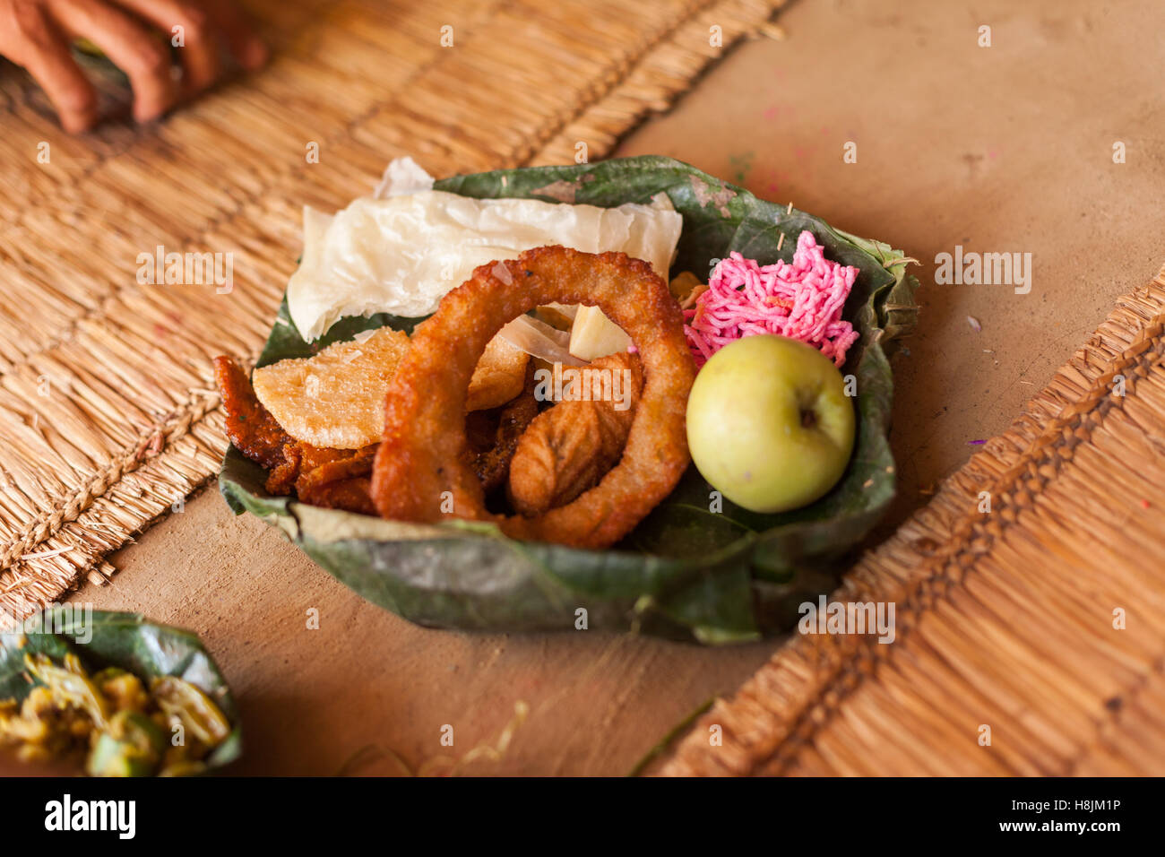 Sel roti, apple, fini, jhlinka, chini roti, khurema on a tapari leaf ...