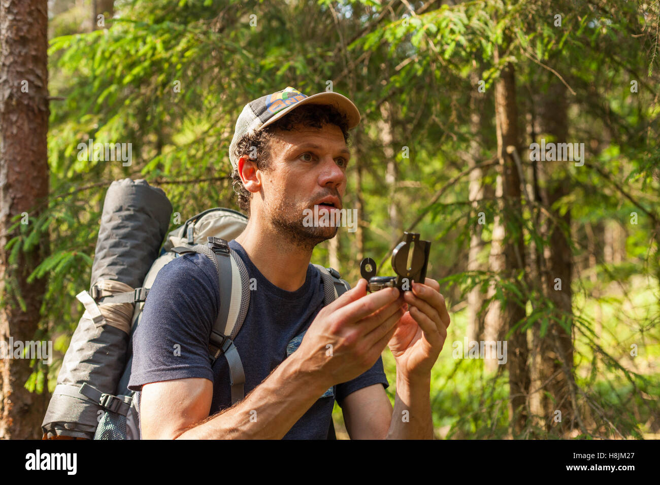 Male hiker navigates through the forest with a compass Stock Photo - Alamy