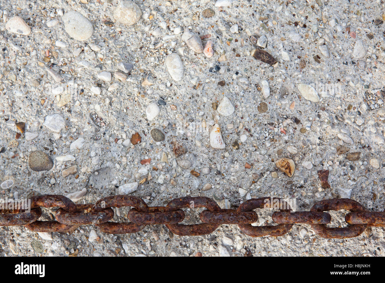 large rusty metal chain on stone wall Stock Photo - Alamy