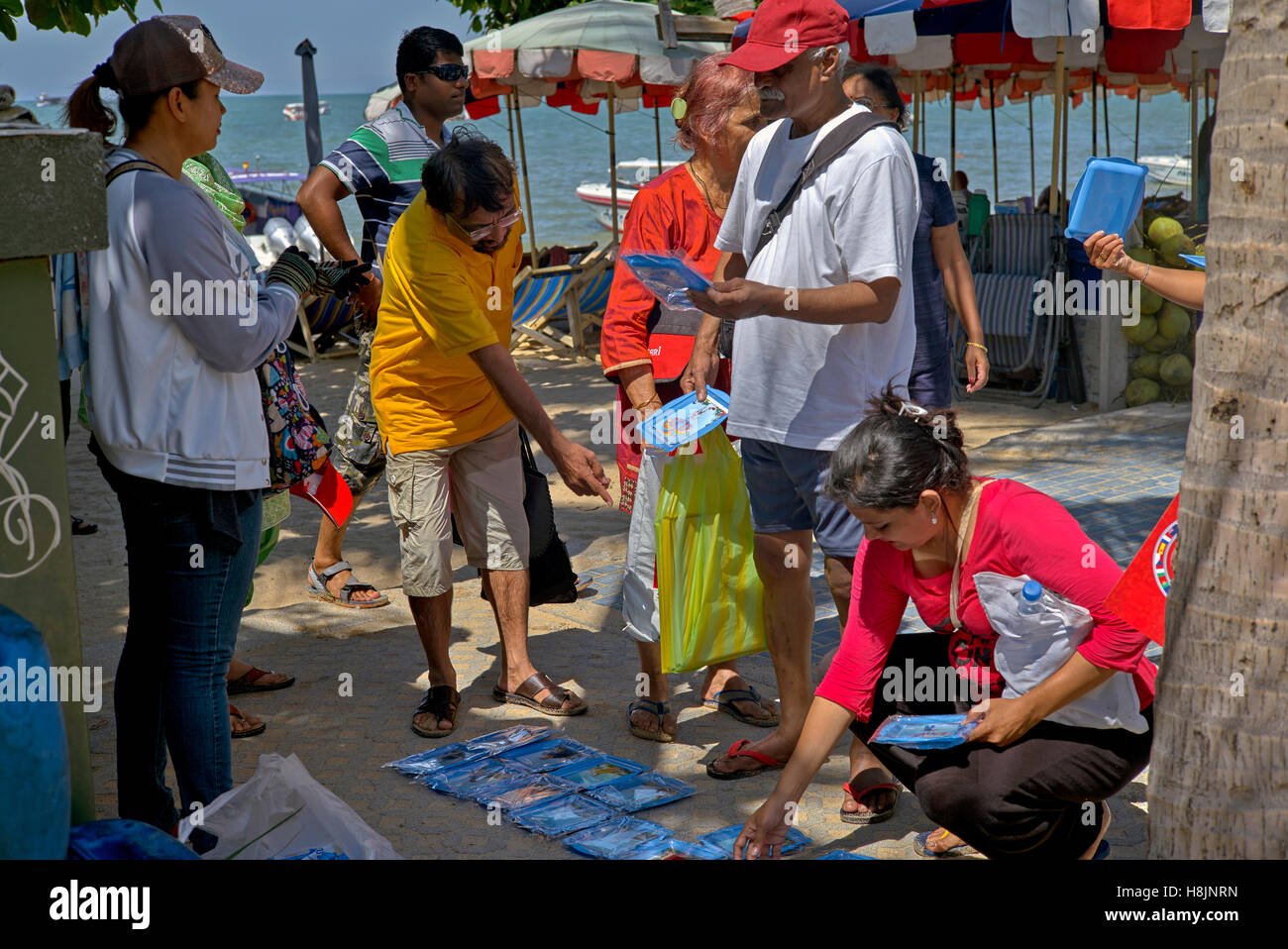 Indian tourists group selecting souvenir photographs of their visit ...