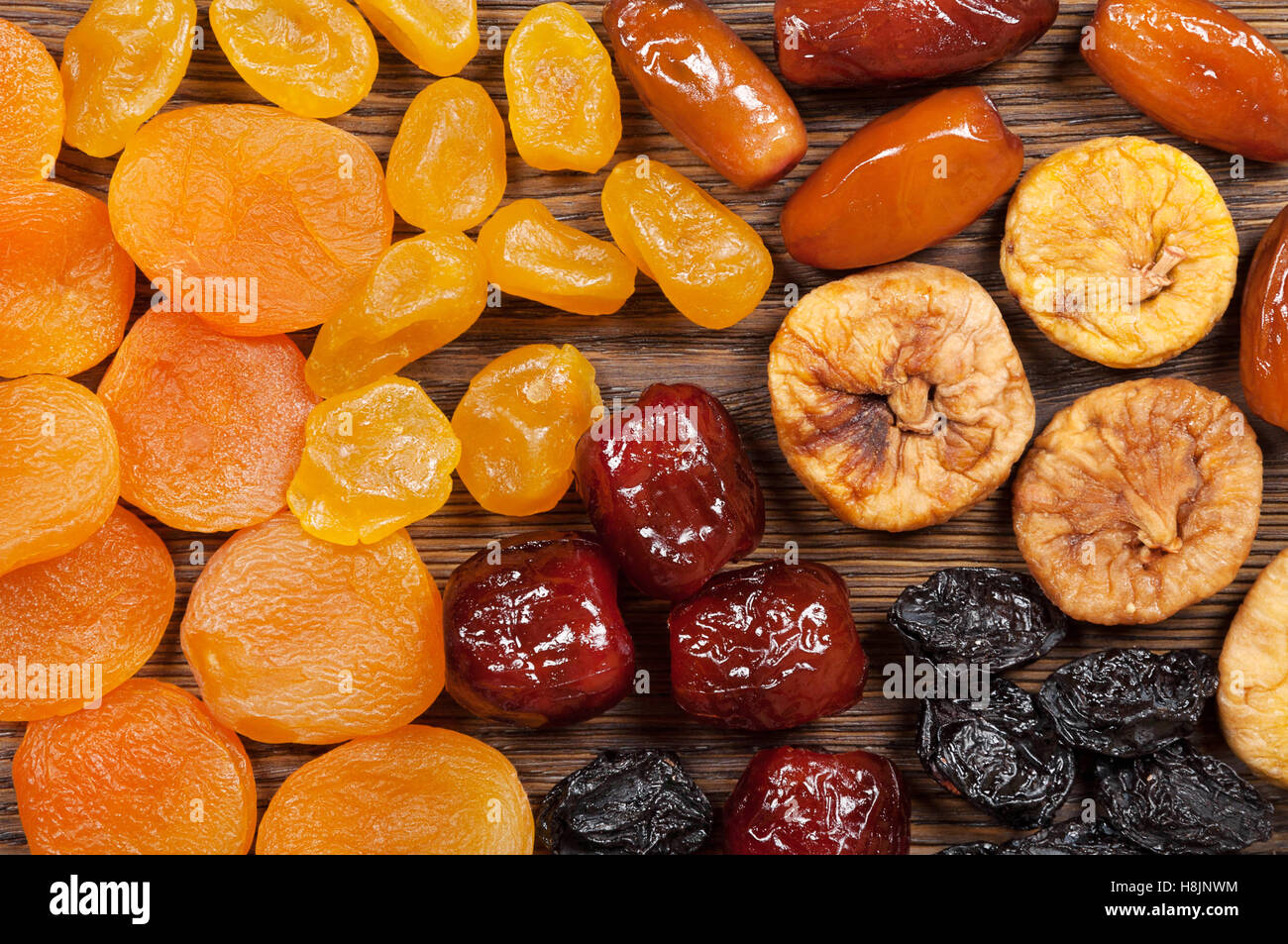Dried fruits scattered on a wooden background. Top view. Candied fruits ...