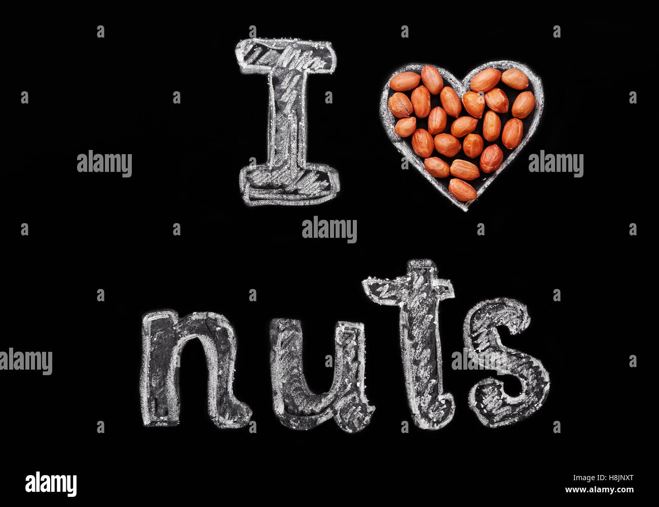 Peanuts on a black background and chalk inscription "I love nuts ...