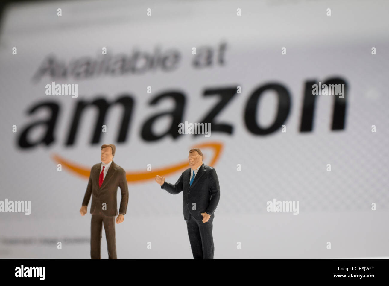 scale models of business people posed in front of amazon logo, the ...