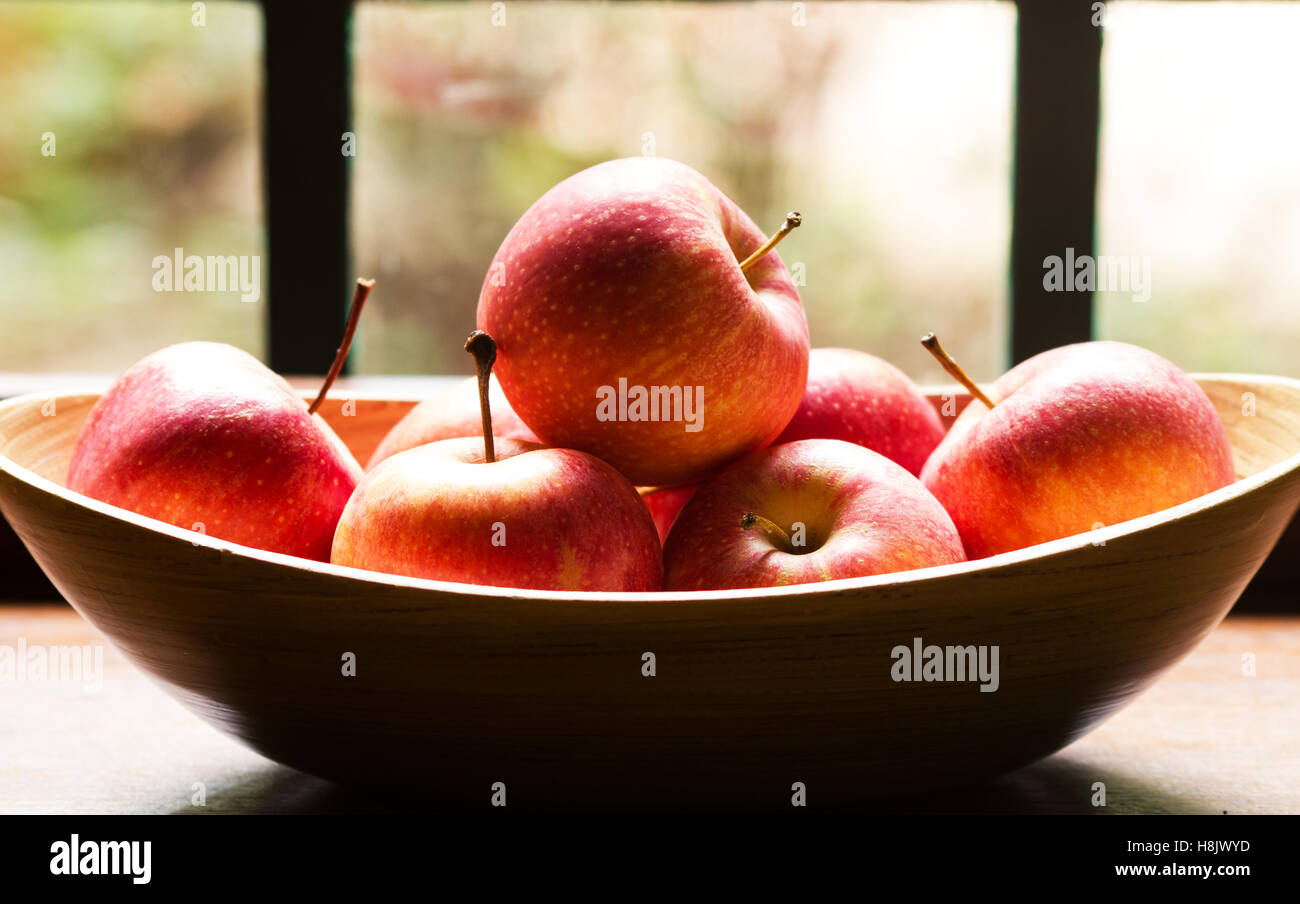 Red apples in a bowl against a window Stock Photo - Alamy