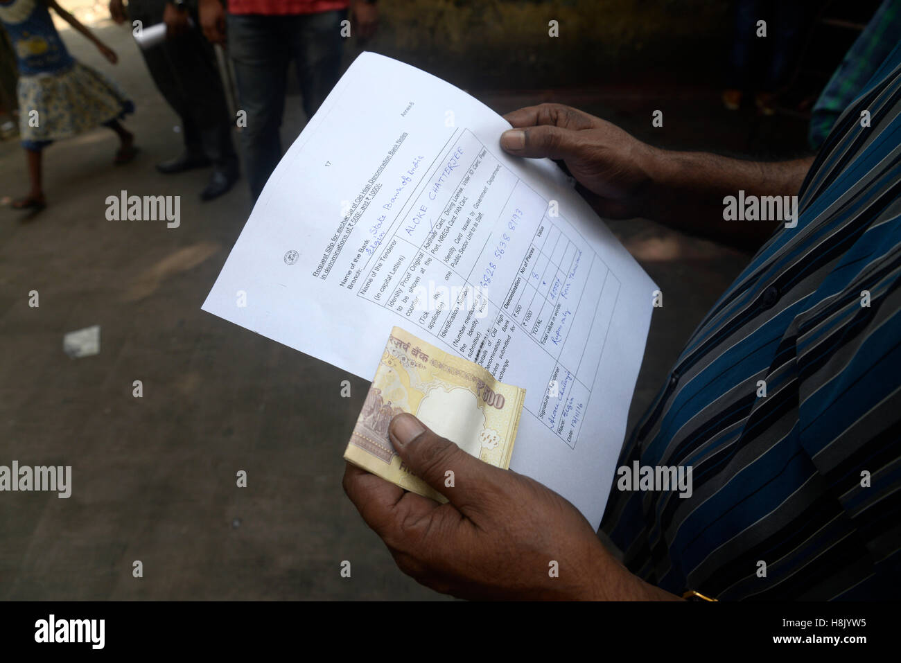 Indian check the filled up from and hold Rs.500 bank note in hand in ...