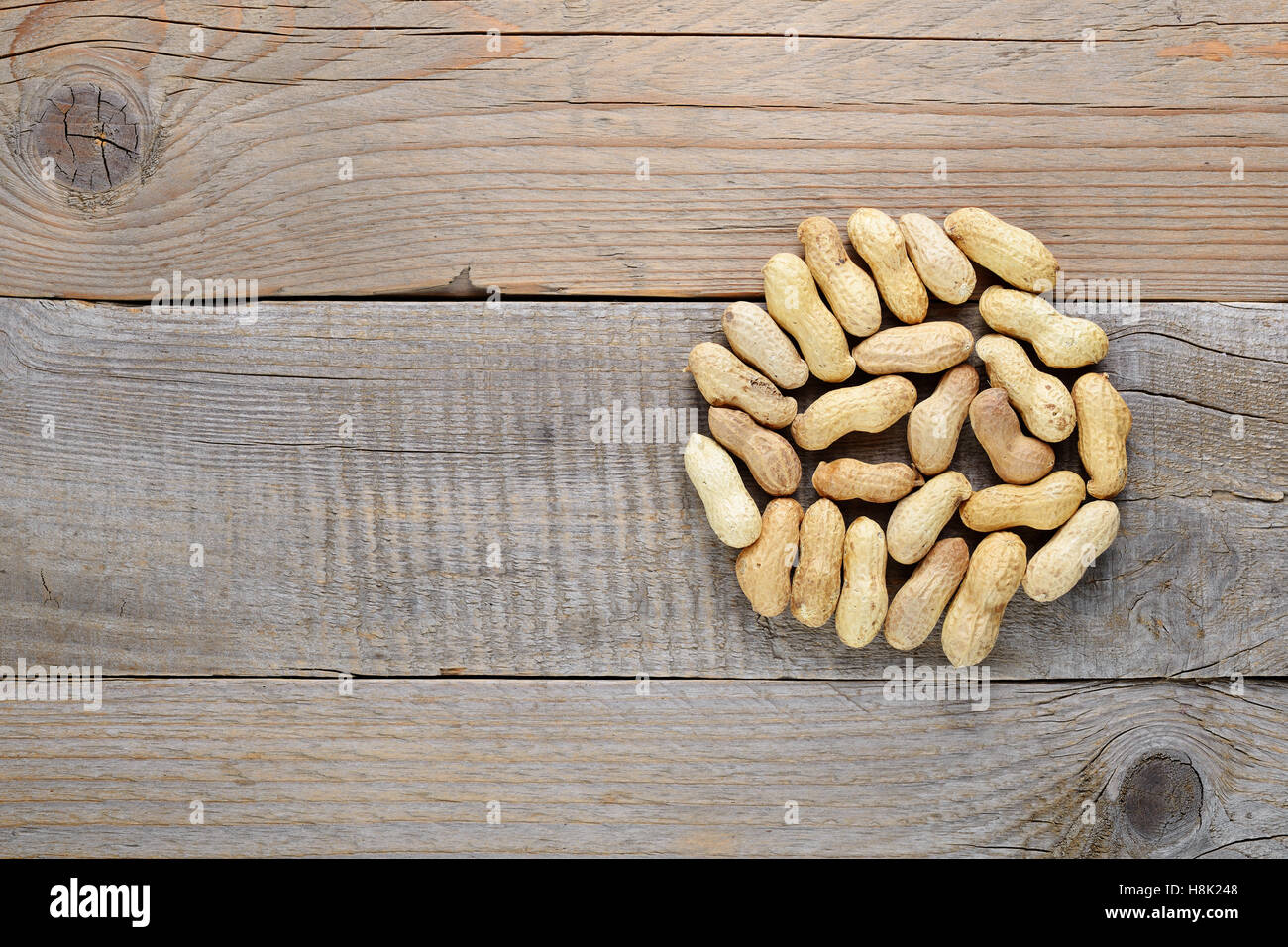 Roasted peanuts in shell on wooden table top view Stock Photo - Alamy
