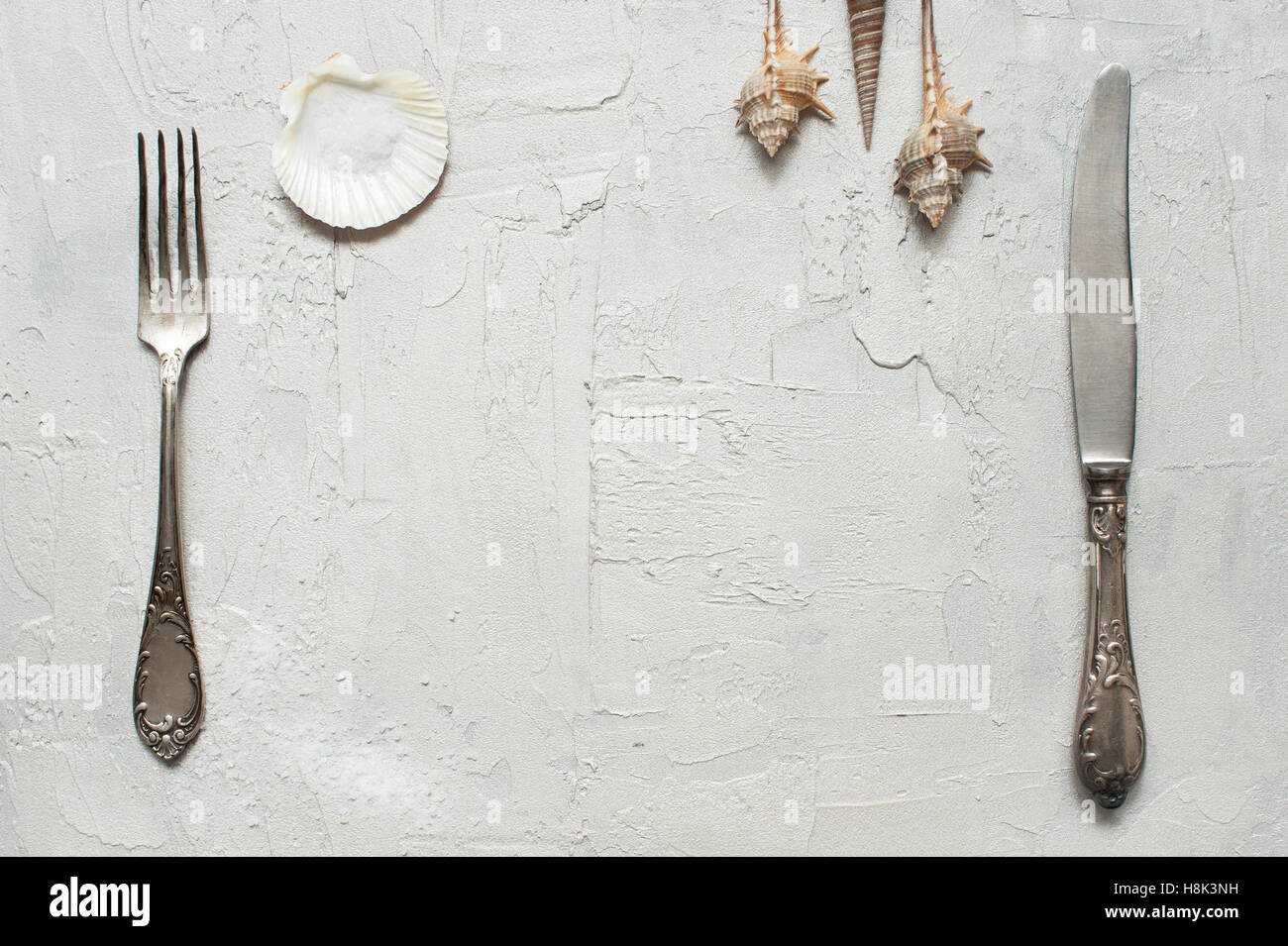Table setting with fork and knife in maritime style in the light colors ...