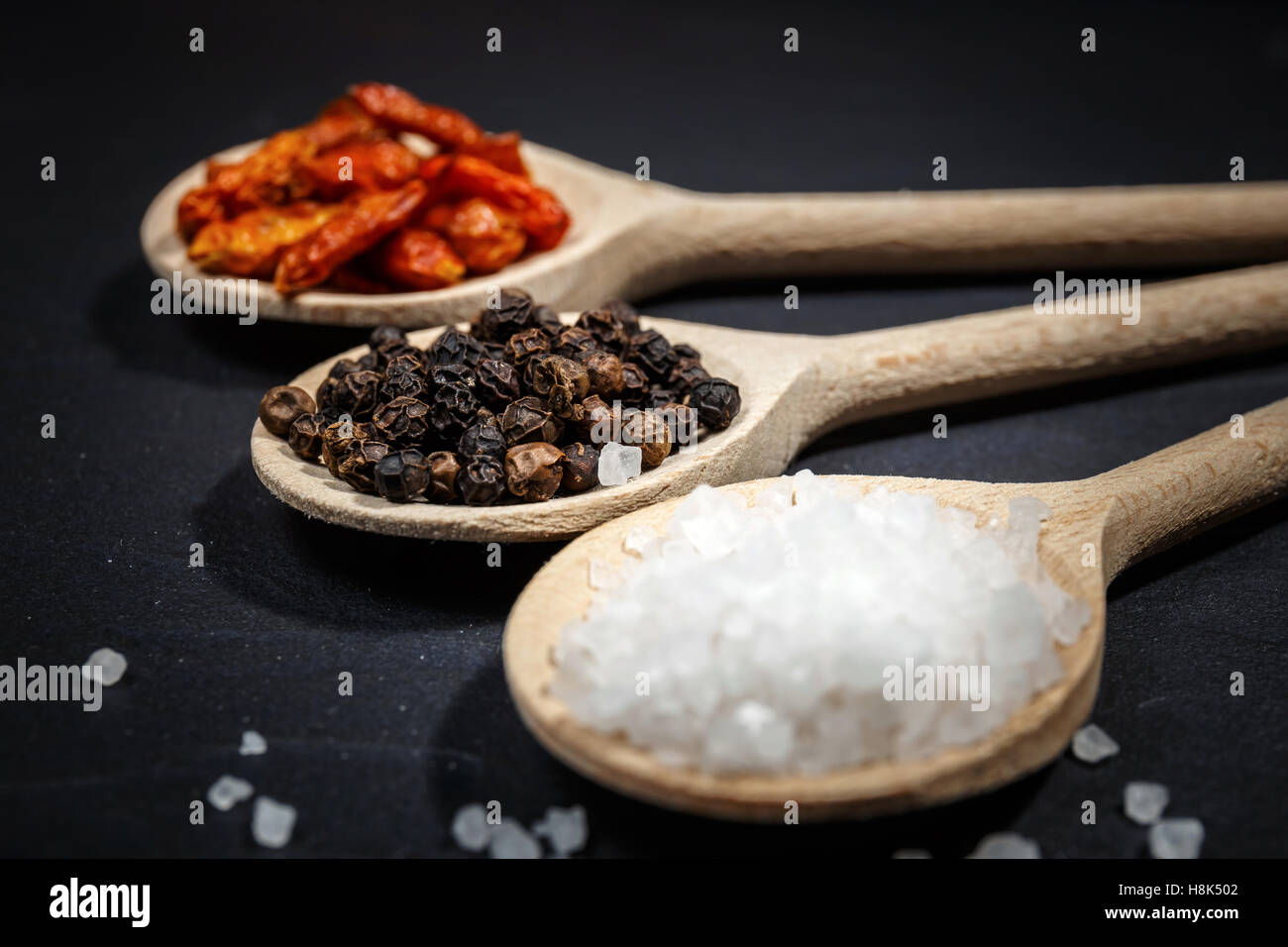 Chili with black pepper and salt on rustic stone background. Overhead ...