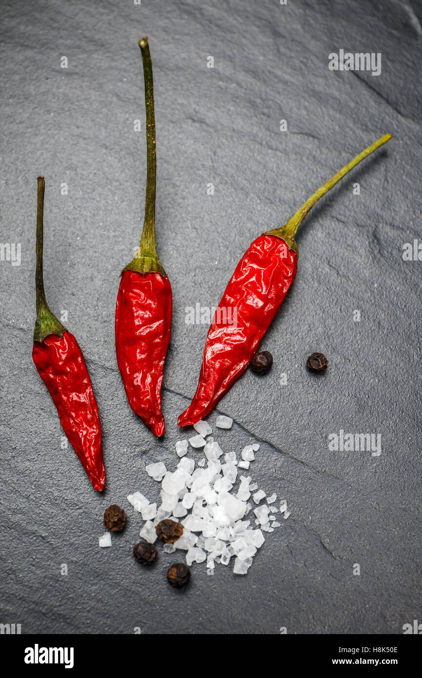 Chili with black pepper and salt on rustic stone background. Overhead ...